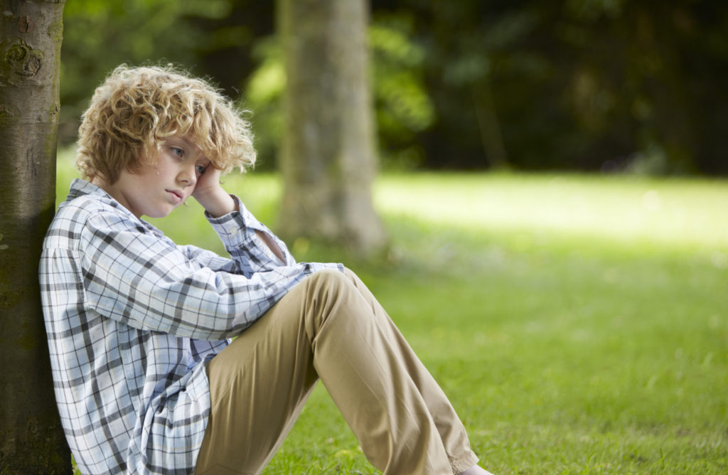 Sad Boy Sitting In Park - School Mum